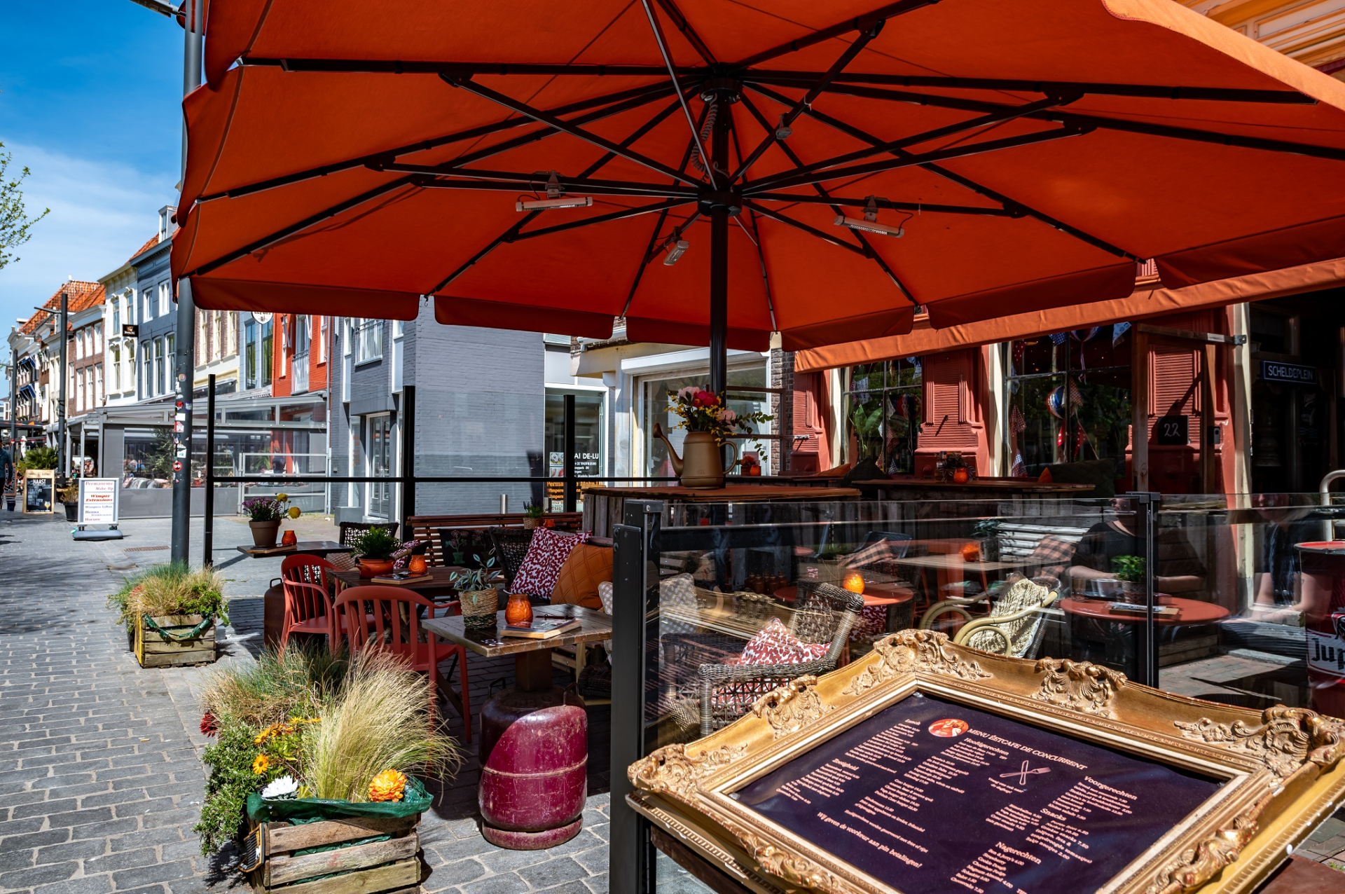 Horecaparasol en inschuifbare glazen windschermen op het terras